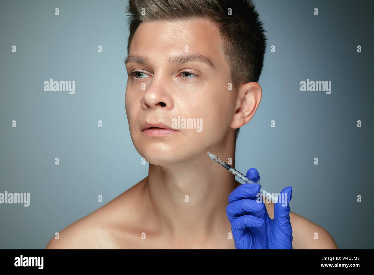 Close-up portrait of young man isolated on grey studio background ...