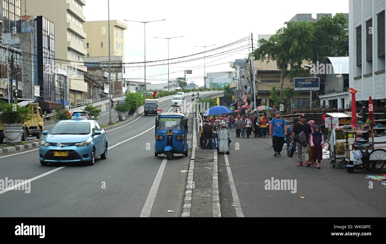 Jakarta, Indonesia - June 2019 : A view of a street with blue bajaj ...