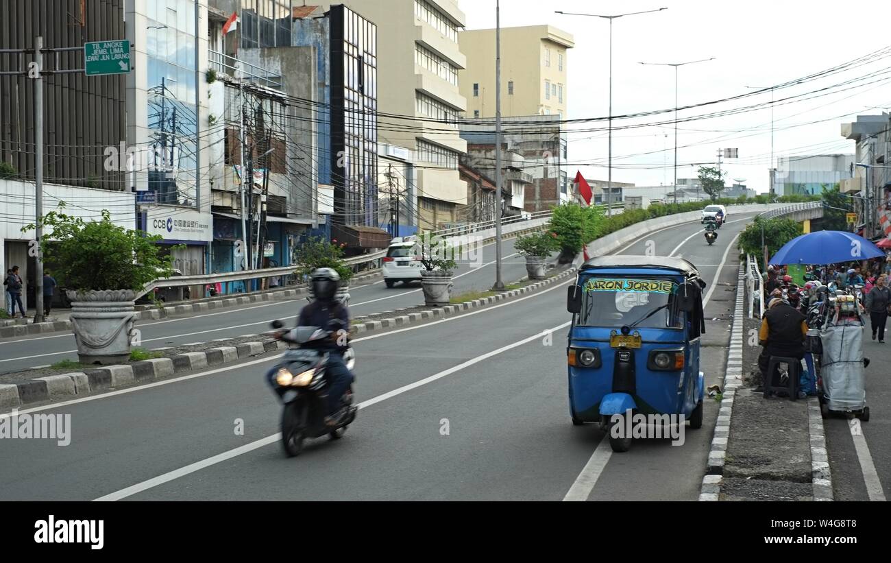 Jakarta, Indonesia - June 2019 : A view of a street with blue bajaj ...