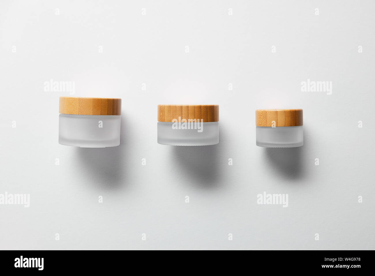 three empty jars for hand cream on white Stock Photo - Alamy