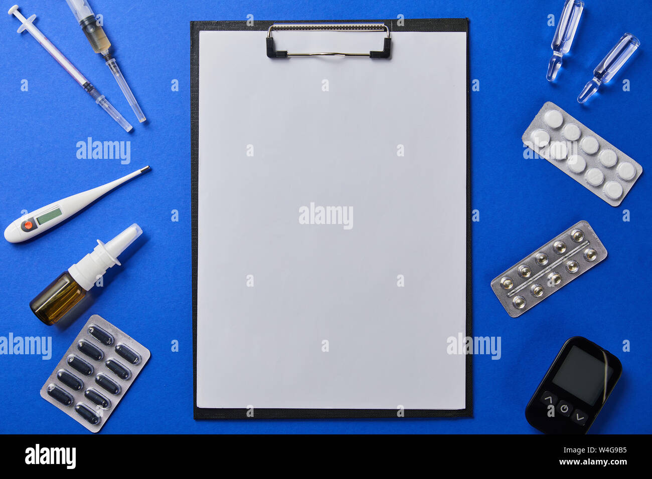 top view of folder with blank paper rounded by various medical supplies ...