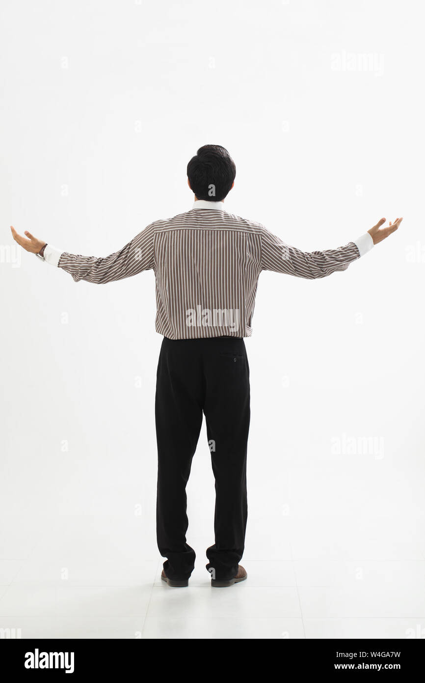 Rear view of a businessman standing with his arm outstretched Stock ...