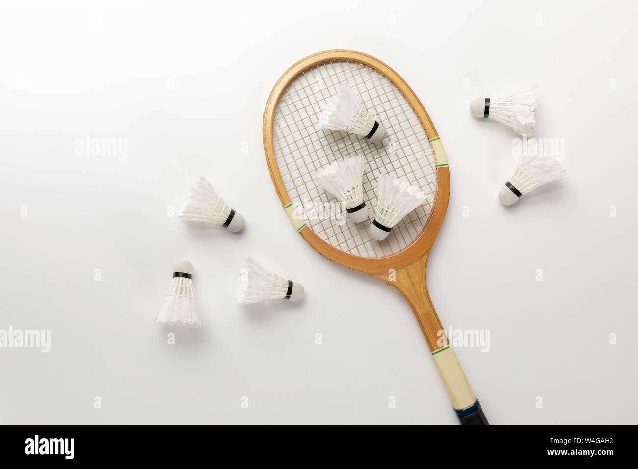top view of wooden badminton racket and shuttlecocks on white ...