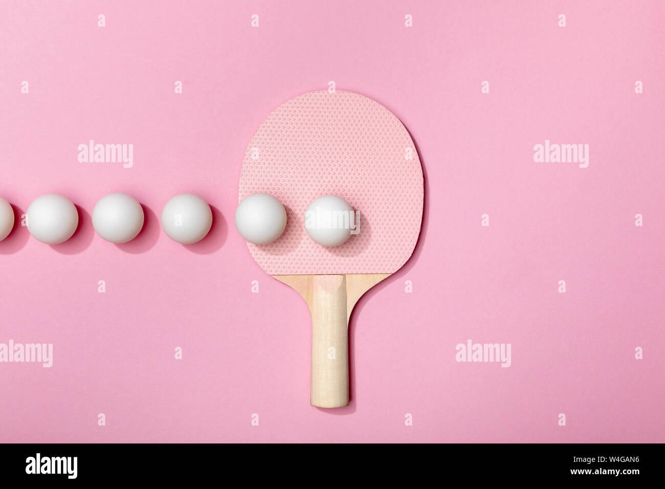 flat lay with white ping-pong balls and racket on pink background Stock ...