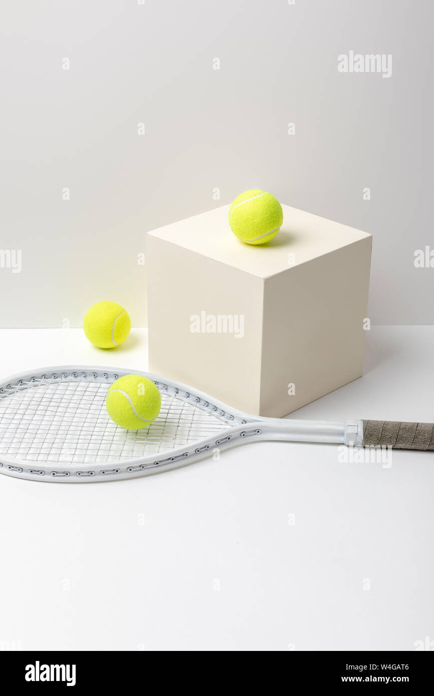 tennis racket and bright yellow tennis balls on cube on white ...
