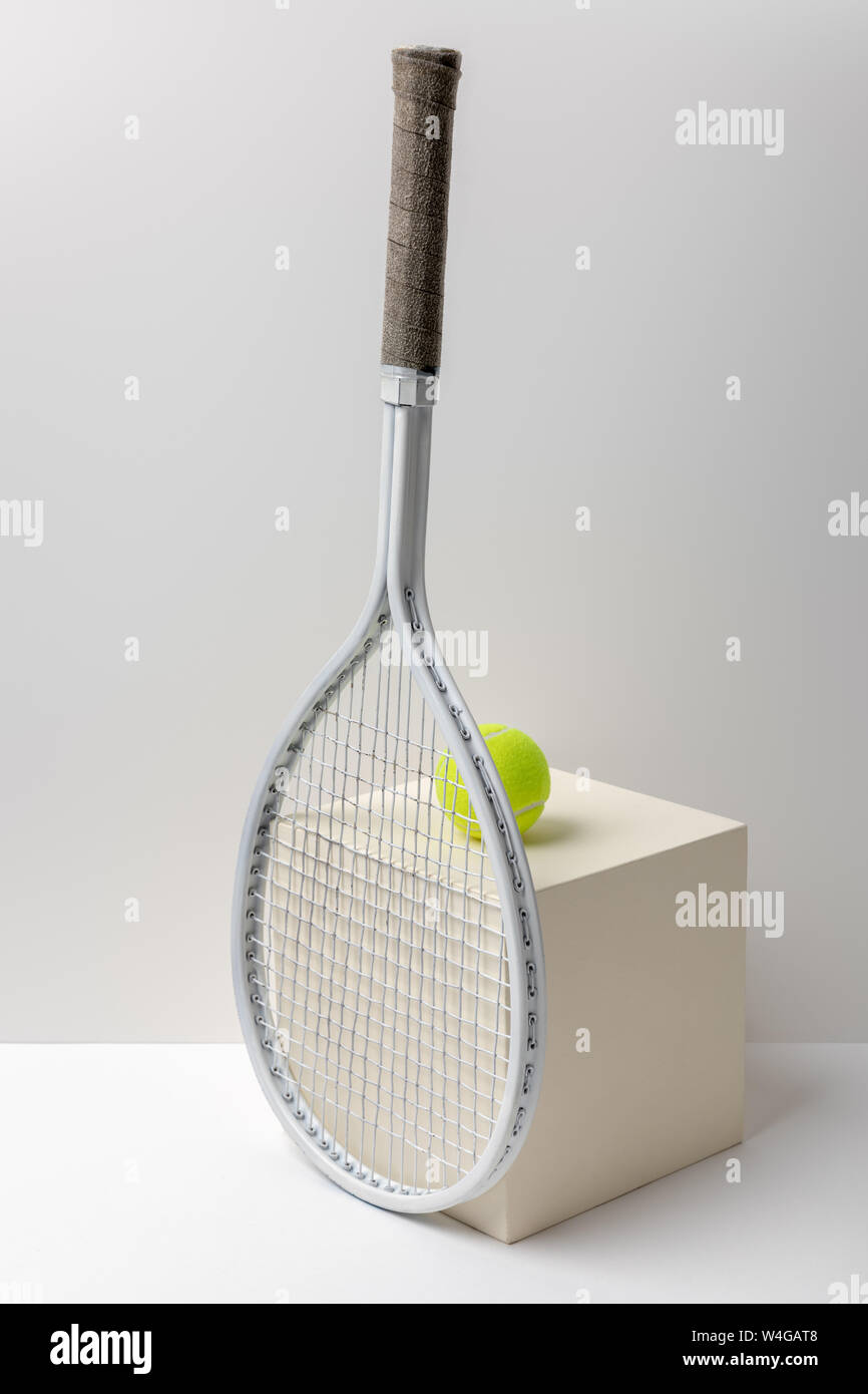 tennis racket and bright yellow tennis ball on cube on white background ...