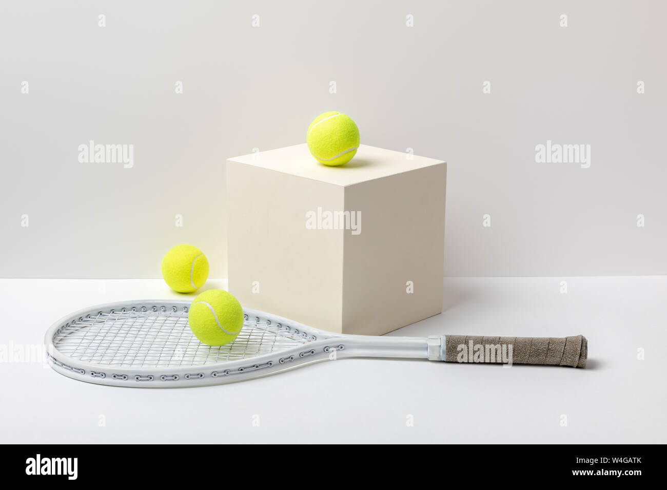 tennis racket and bright yellow tennis balls on cube on white ...