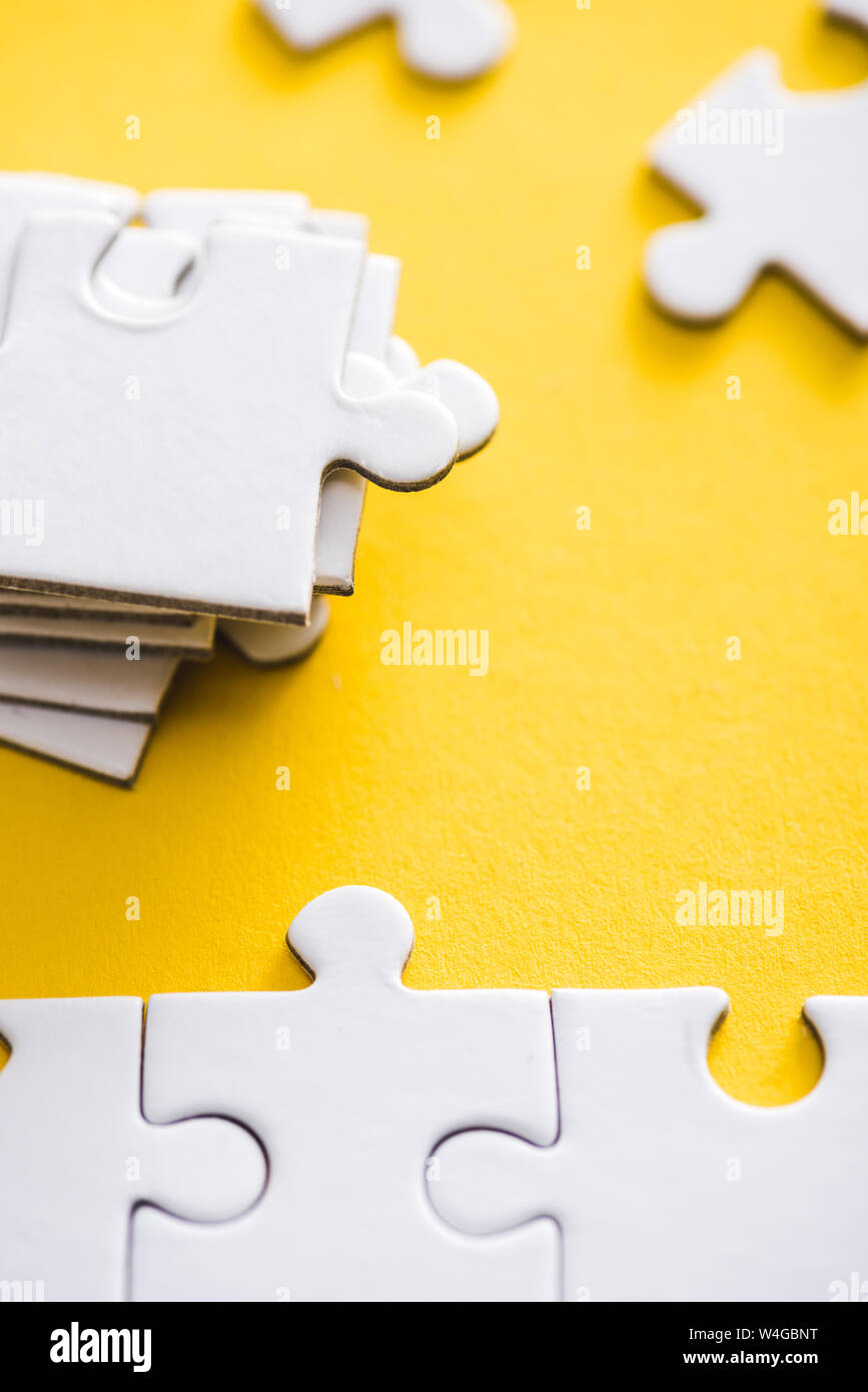 selective focus of connected and incomplete puzzle pieces on yellow ...