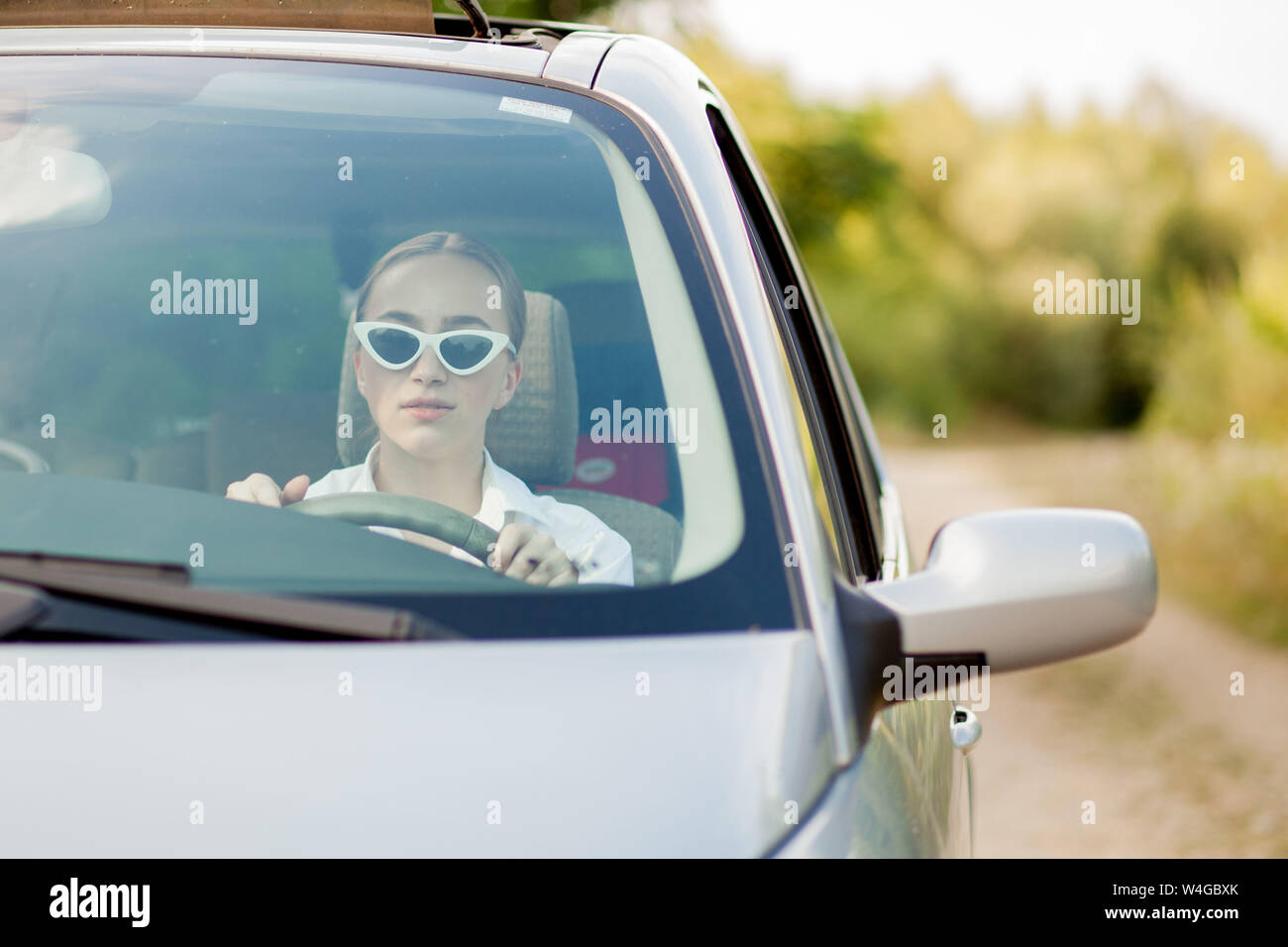 Portrait shot through windshield of pretty woman in car Stock Photo - Alamy