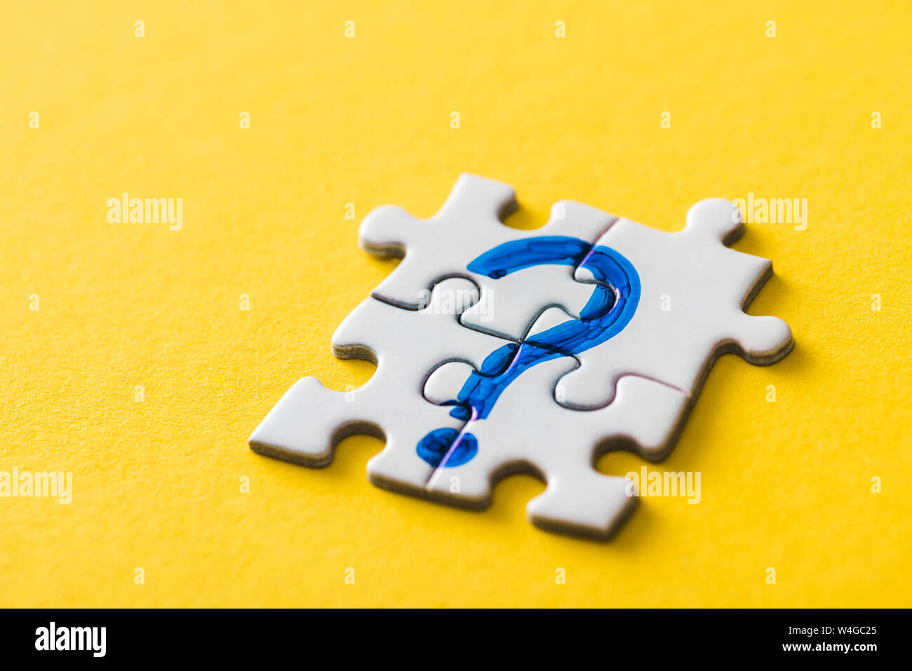 connected jigsaw puzzle pieces with drawn blue question mark on yellow ...