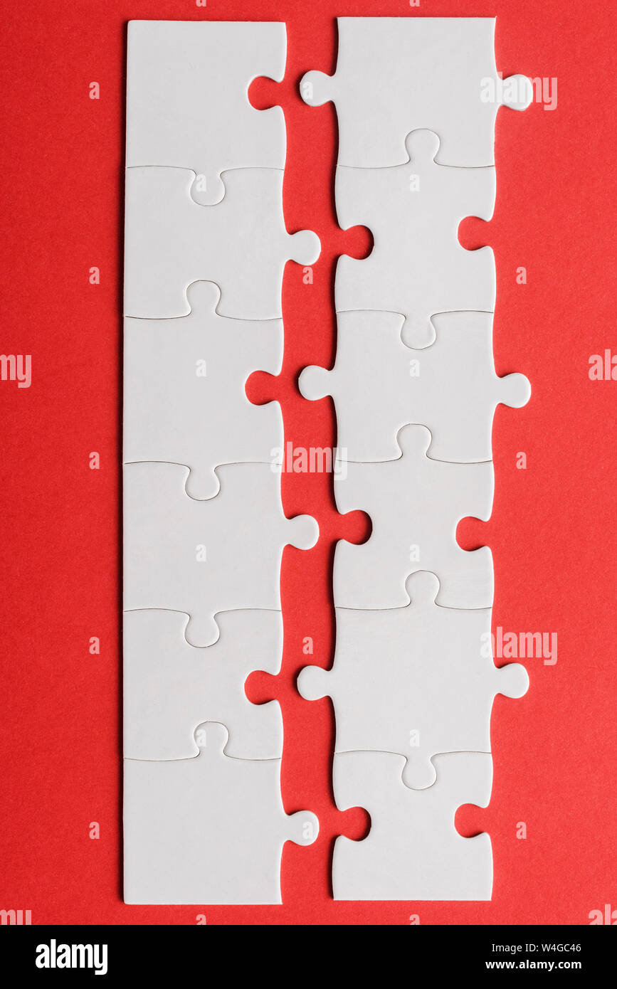 top view of white lines of connected jigsaw puzzle pieces on red Stock ...