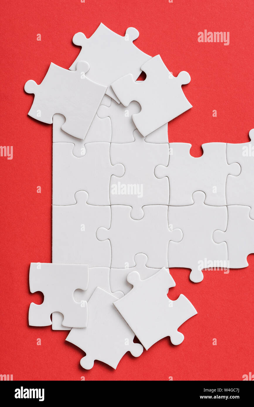top view of white unfinished jigsaw near connected puzzle pieces ...