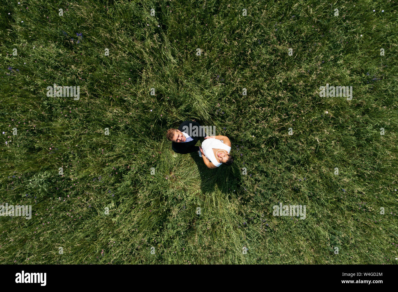 Aerial view of pregnant bride with her husband on a meadow Stock Photo ...