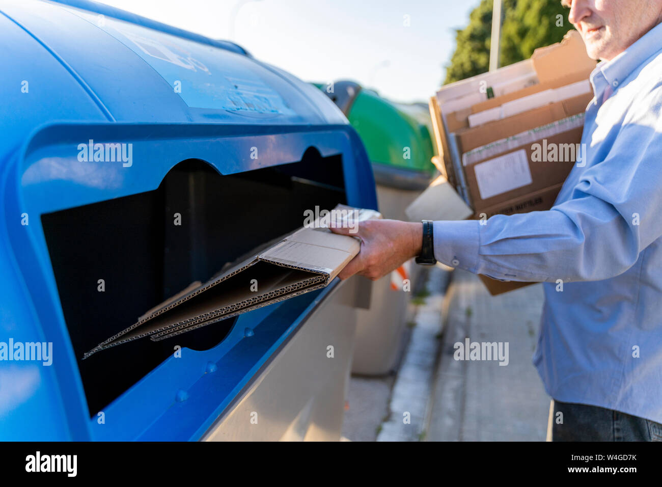 Senior man recycling cardboard in paper bank Stock Photo - Alamy