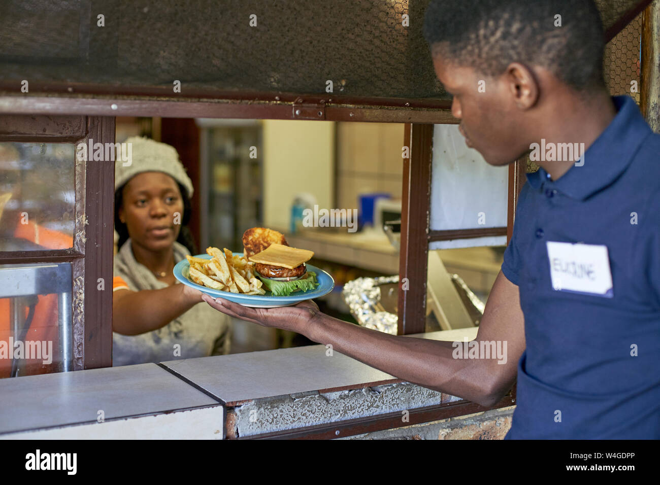 Young waiter taking delivered food from the restaurant kitchen hi-res ...