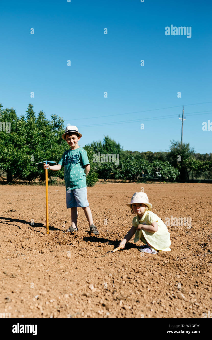 Boy and girl plowing the ground Stock Photo - Alamy
