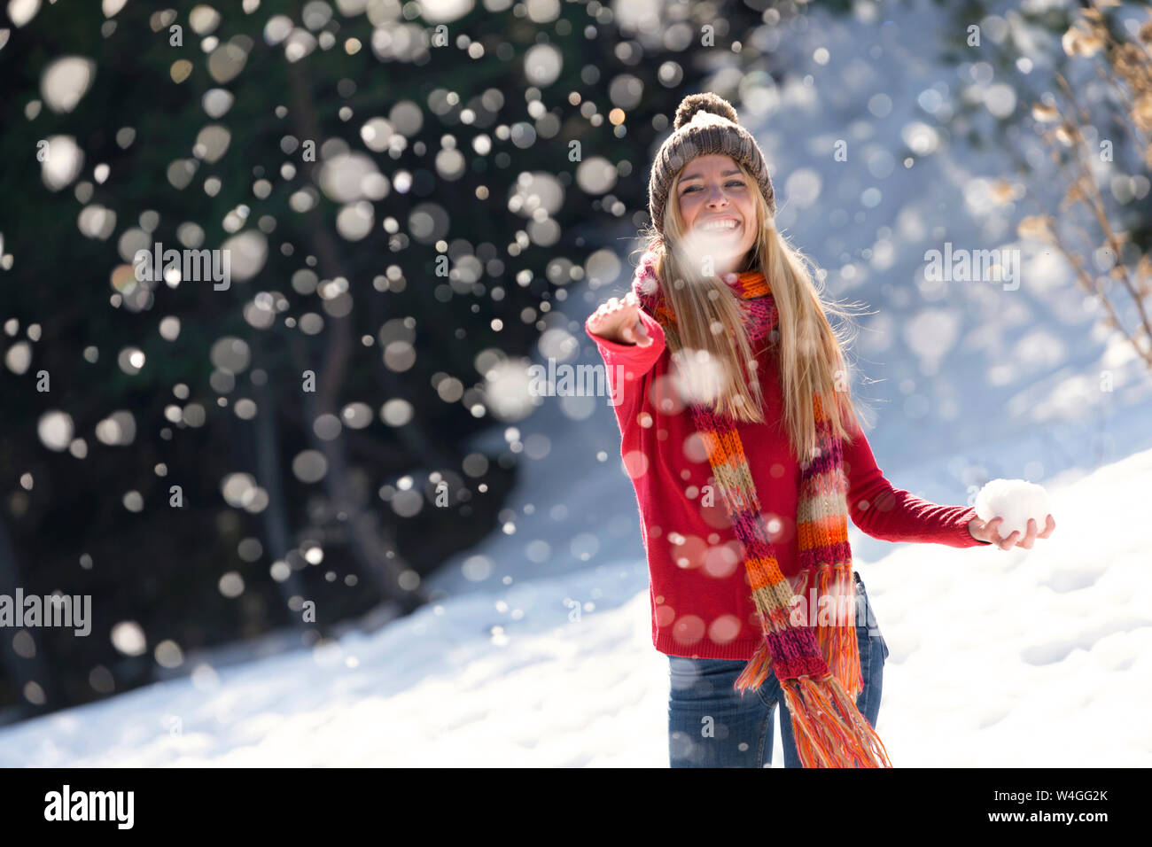 Young blond woman throwing with snow in winter Stock Photo - Alamy