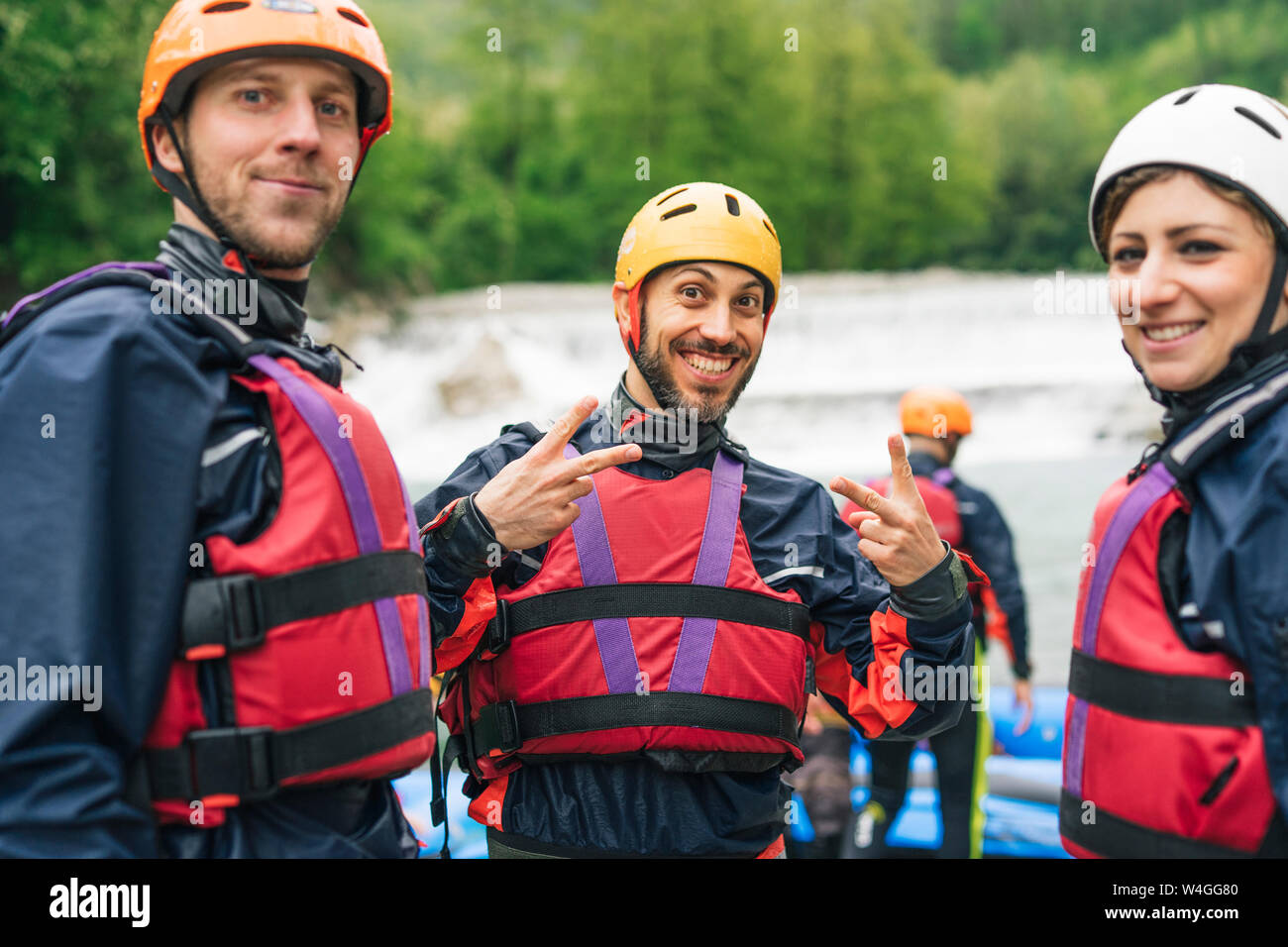 Happy friends at a rafting class posing at river shore Stock Photo - Alamy