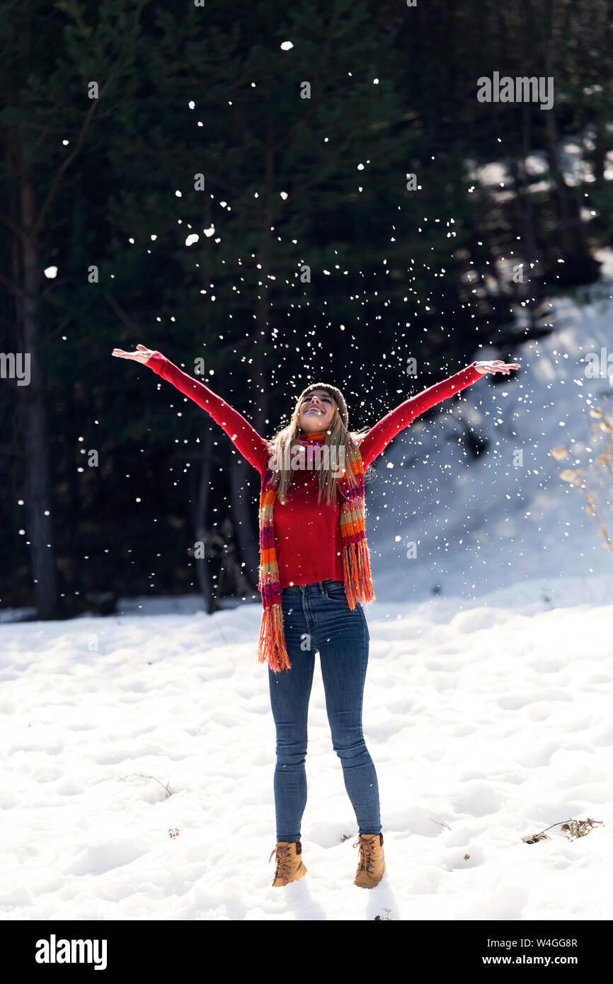 Young blond woman throwing snow in winter Stock Photo - Alamy