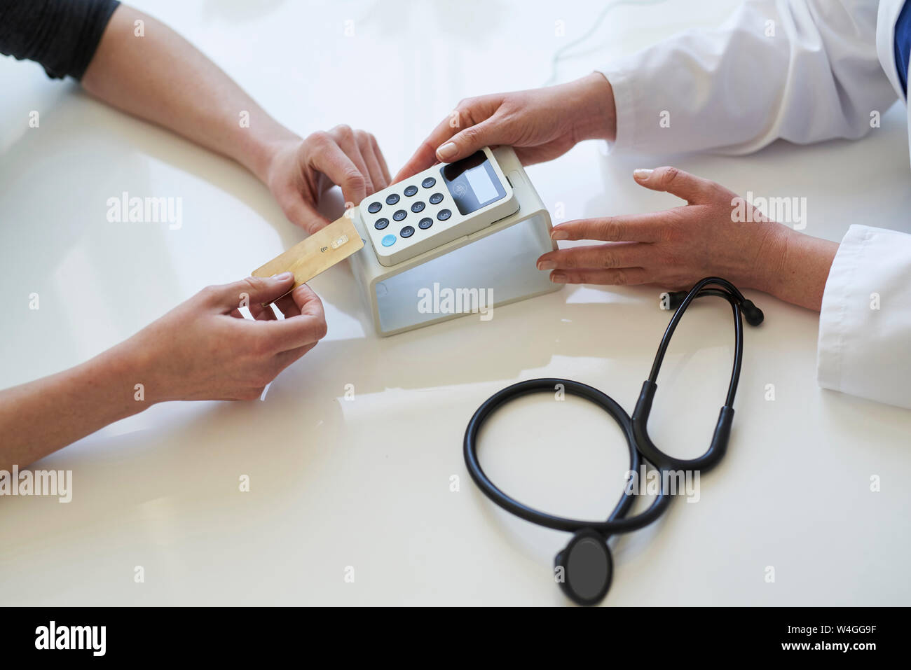 Doctor and patient with card and card reader at medical practice Stock ...