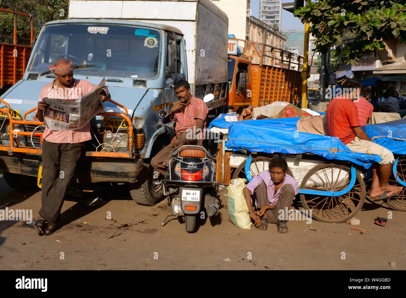 Truck drivers and their helpers taking a rest in a poor neighborhood in ...