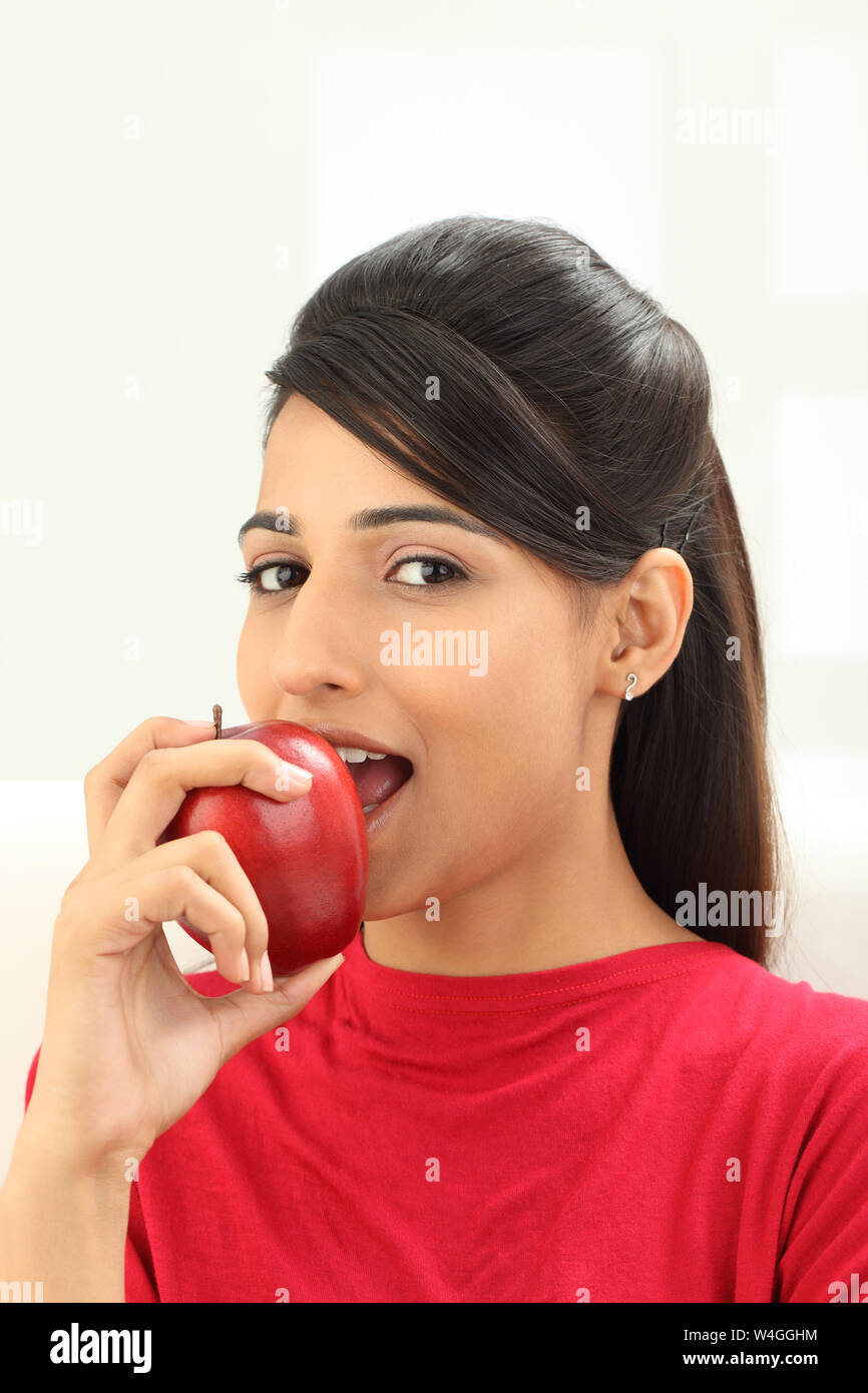 Portrait of a woman eating an apple Stock Photo - Alamy