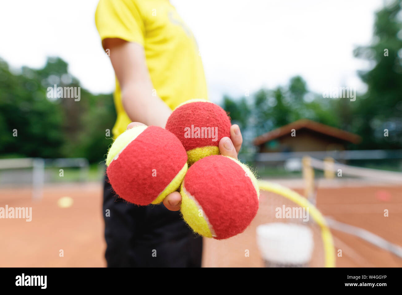 Boy on the tennis court, holding tennis balls Stock Photo - Alamy