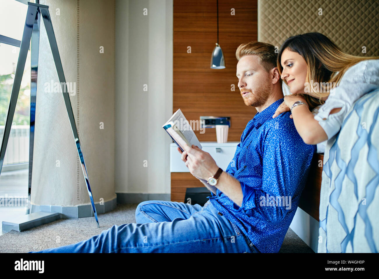 Affectionate couple reading book together in bedroom Stock Photo - Alamy