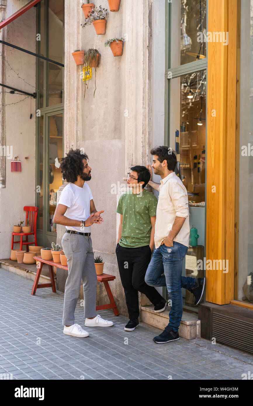 Three young men talking in the city Stock Photo - Alamy