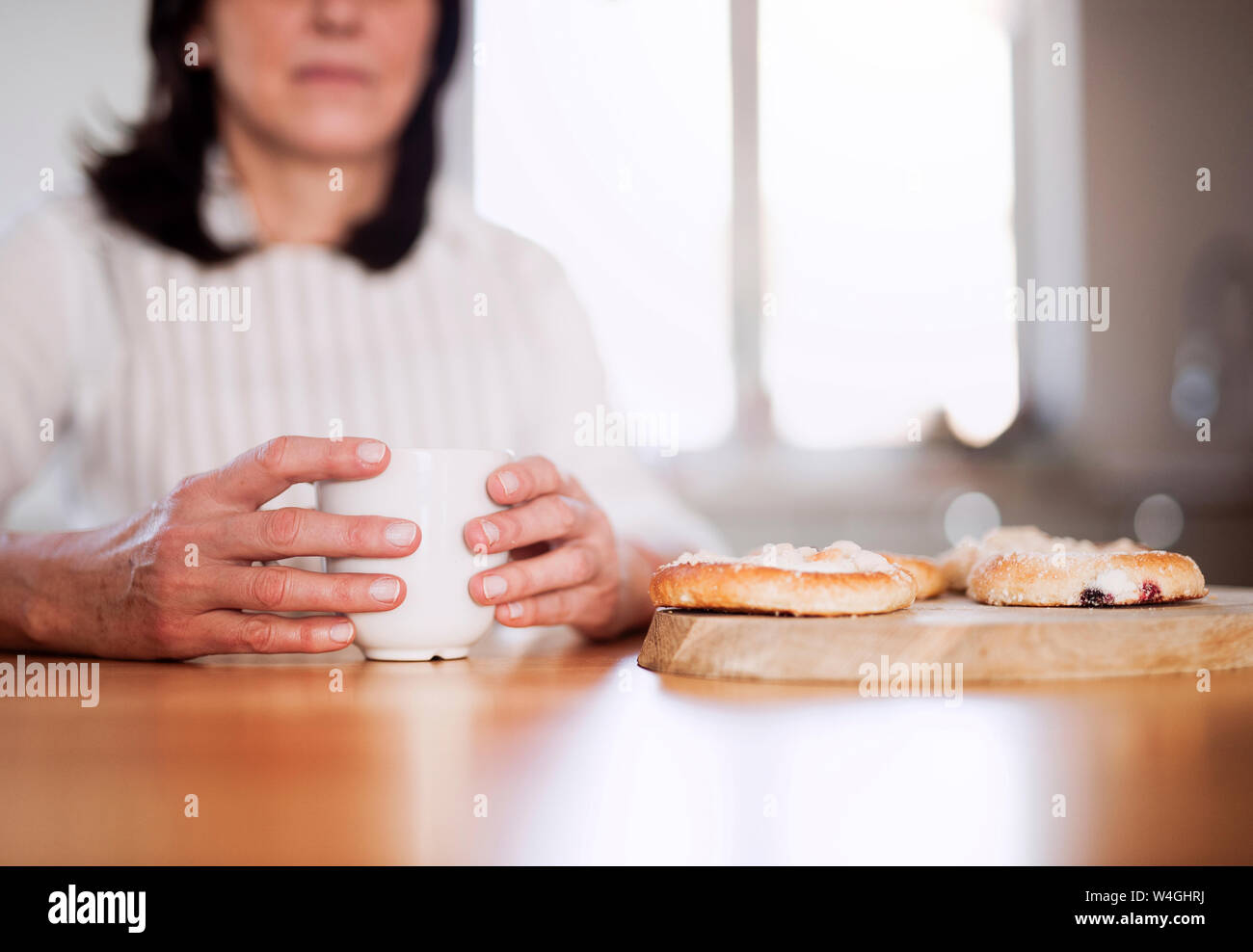 Mature woman sitting kitchen hi-res stock photography and images - Alamy