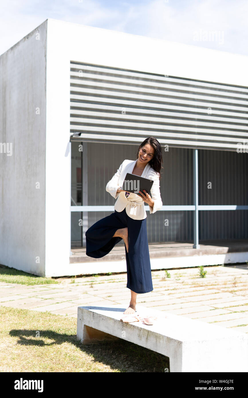 Female ballet dancer using tablet in front of an office during work ...