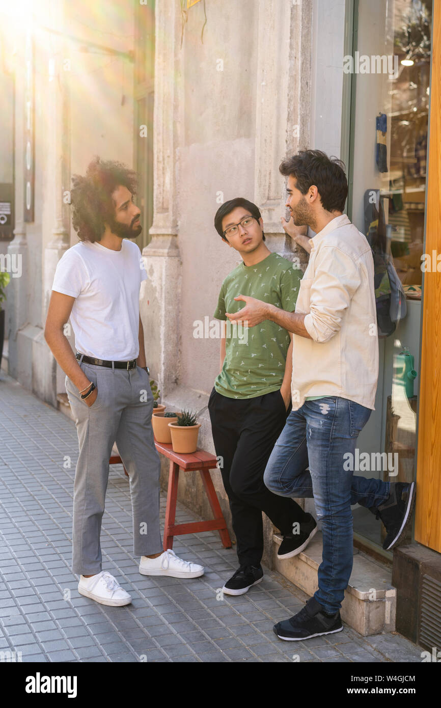 Three young men talking in the city Stock Photo - Alamy