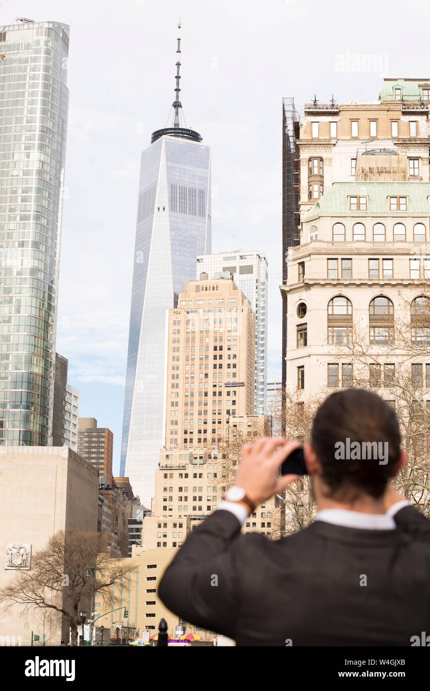 Back view of man taking pictures with smartphone, New York City, USA ...