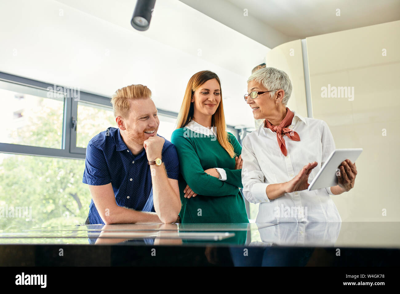 Shop assistant with tablet talking to couple shopping for a new kitchen ...
