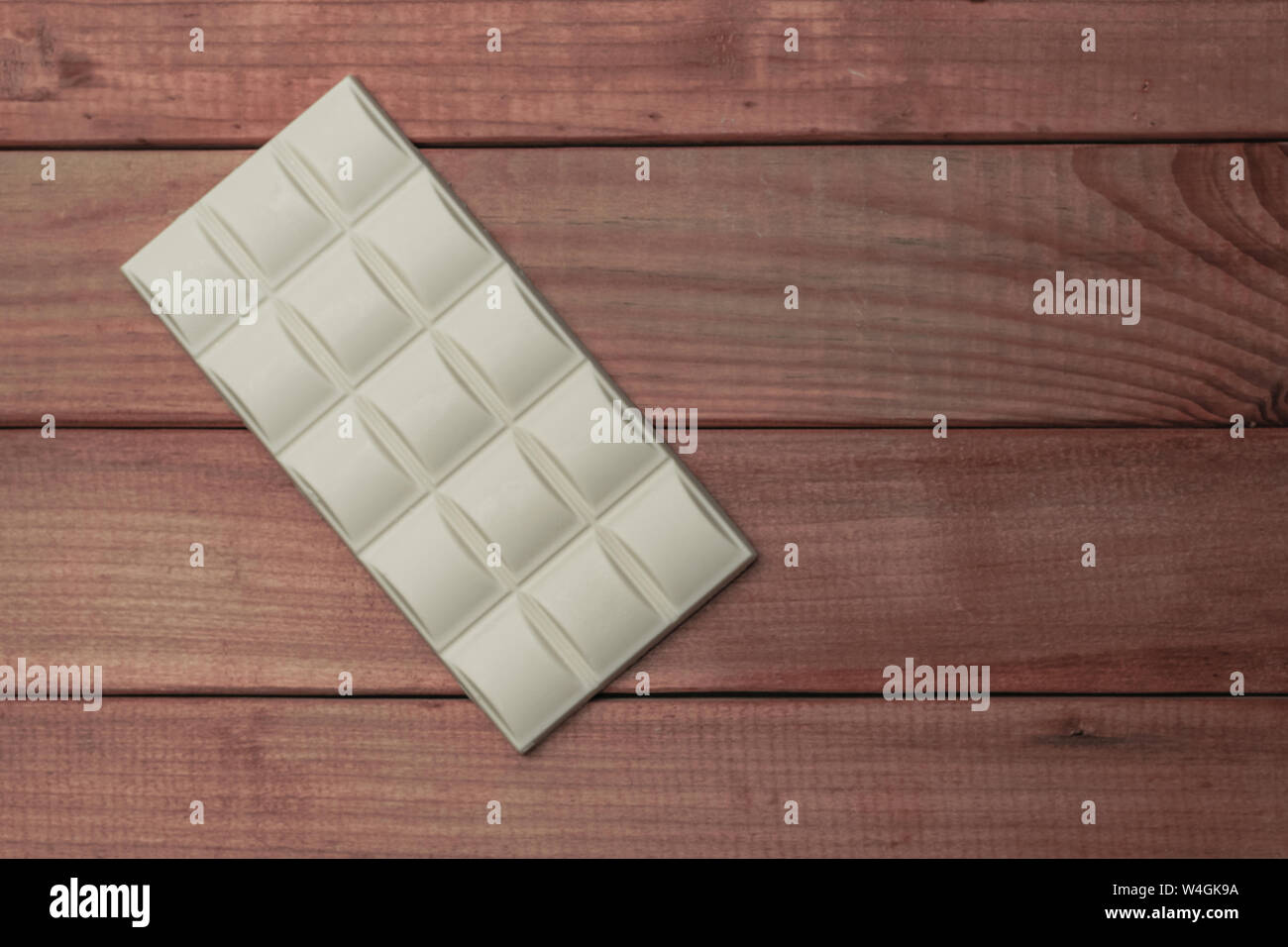 White chocolate on a red wooden table background Stock Photo - Alamy