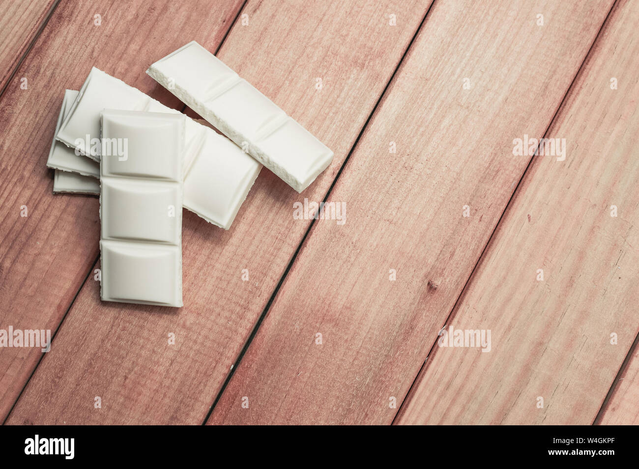 White chocolate on a red wooden table background Stock Photo - Alamy