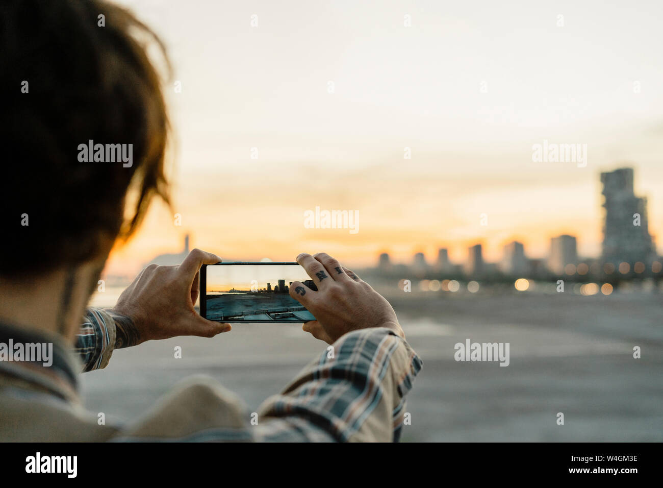 Back view of man taking photo during sunset hi-res stock photography ...