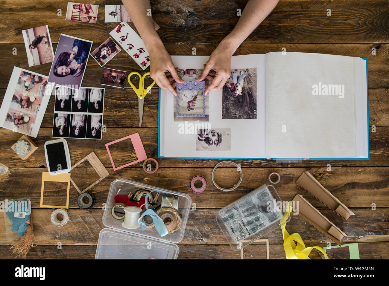 Top view of woman's hands designing photo album Stock Photo - Alamy