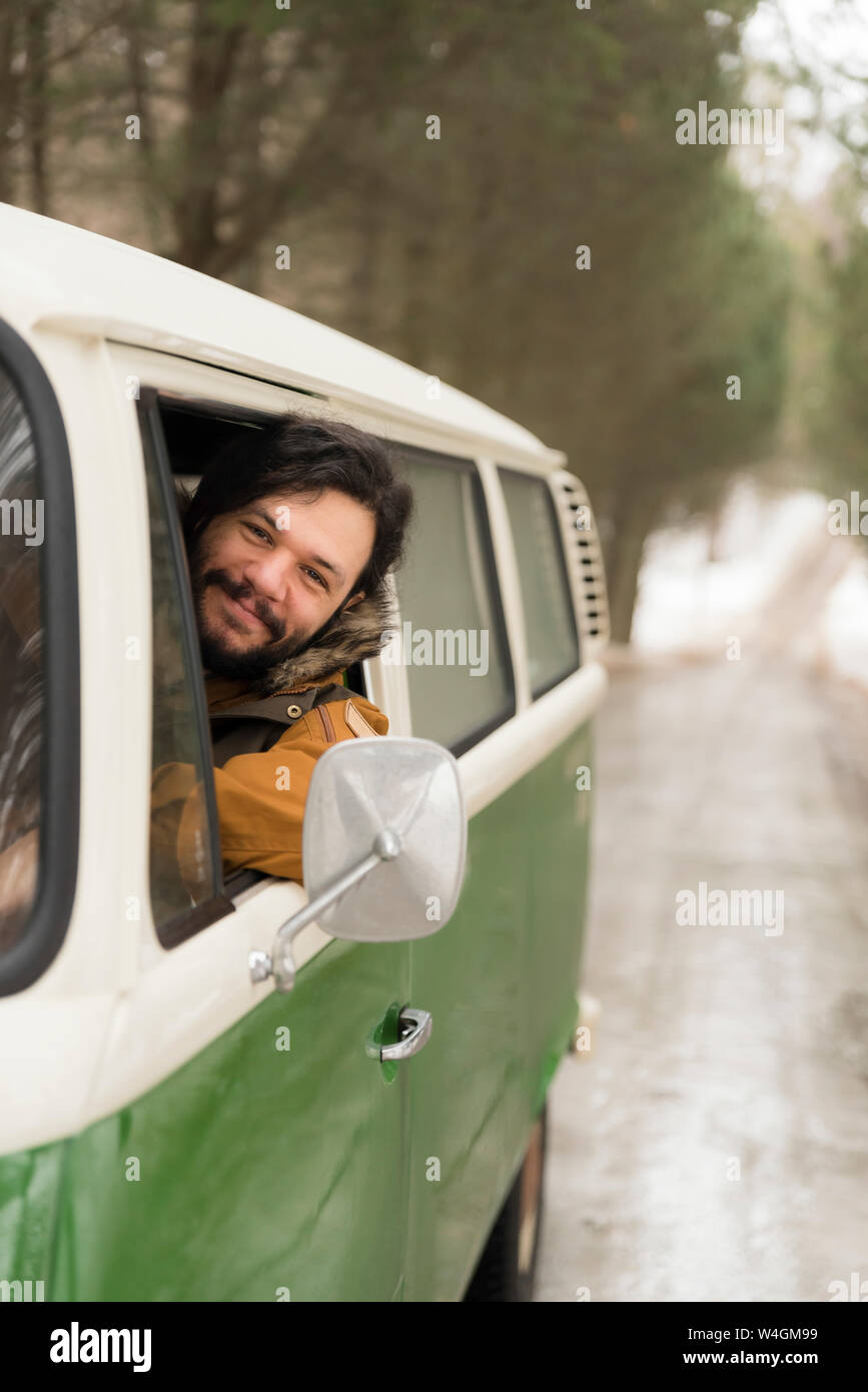 Portrait of smiling man with electric van in winter landscape hi-res ...