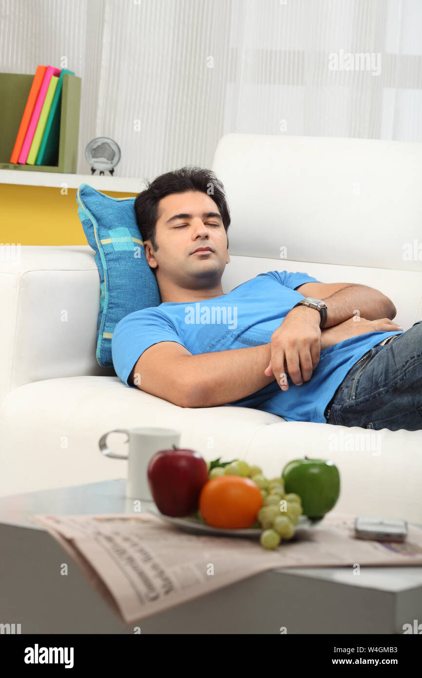 Man sleeping on couch at home Stock Photo - Alamy