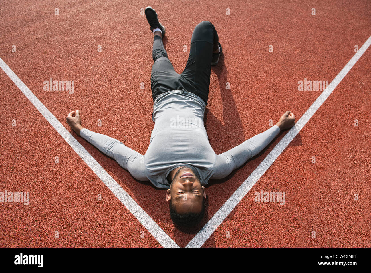Sportsman lying on rubber racetrack Stock Photo - Alamy