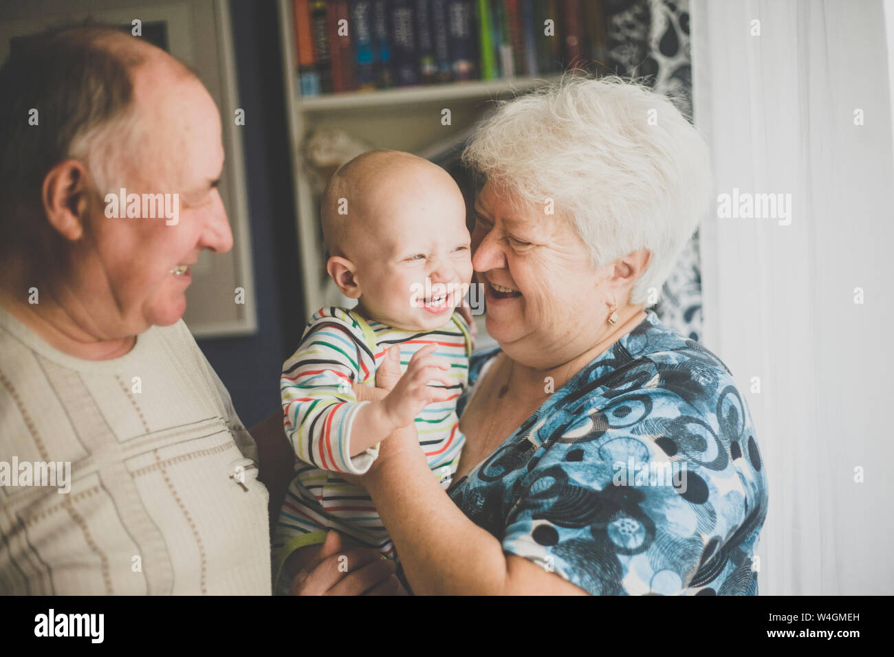 Happy grandparents holding their baby grandson Stock Photo - Alamy