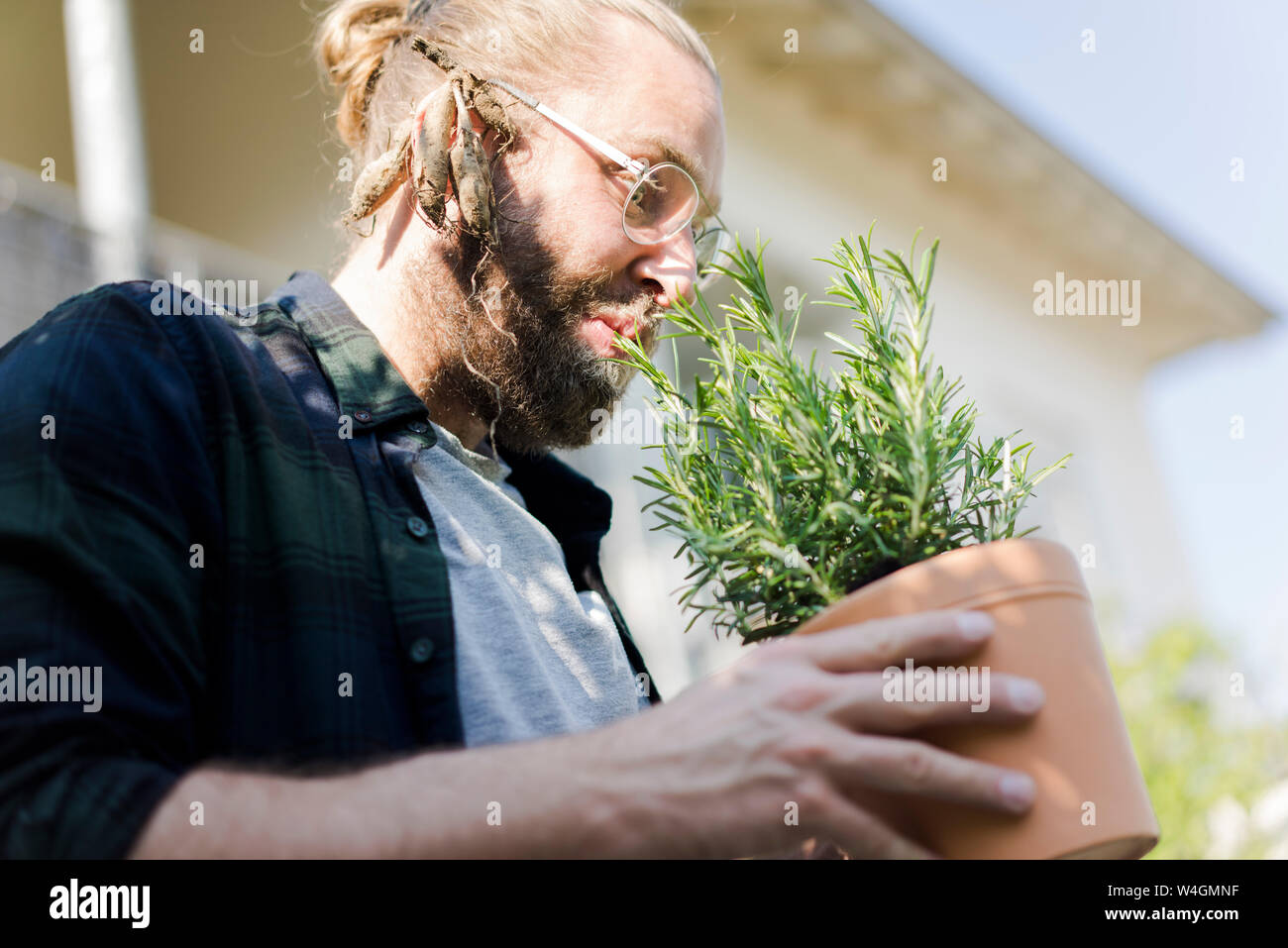 Funny man smelling at rosemary Stock Photo - Alamy