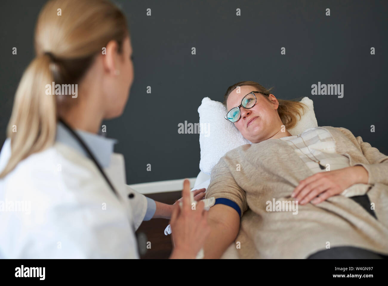Female doctor preparing a blood sampling from patient in medical ...