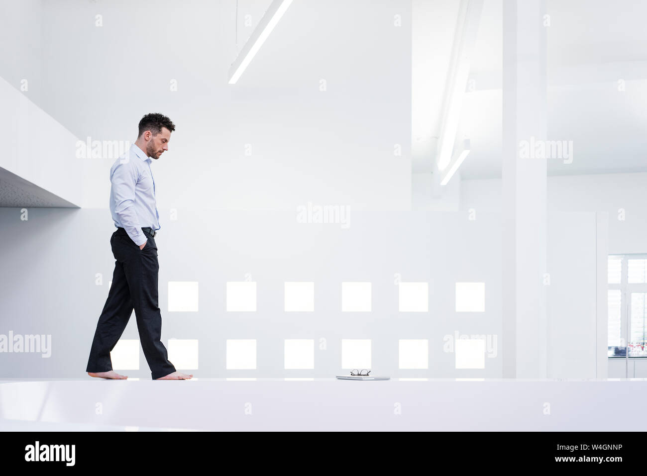 Barefoot businessman walking on reception desk in office Stock Photo ...