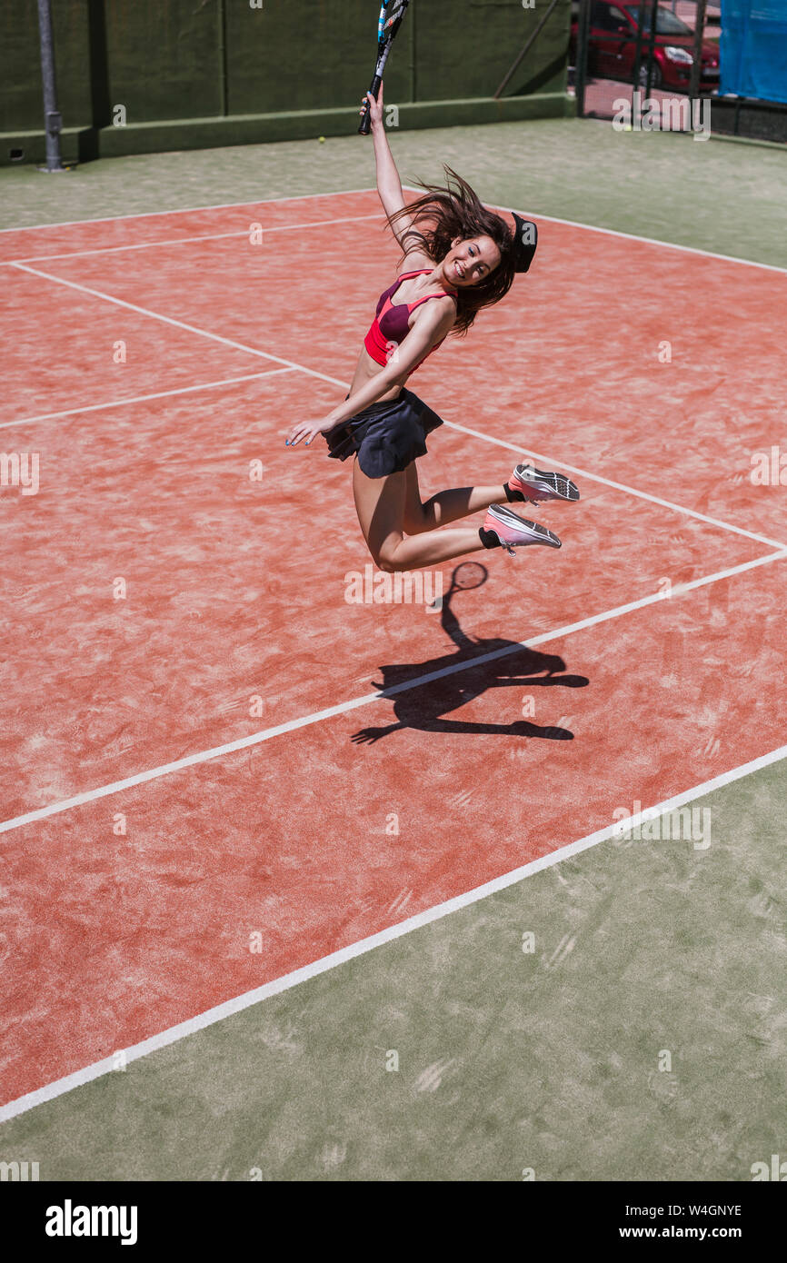 Happy female tennis player cheering on court Stock Photo - Alamy