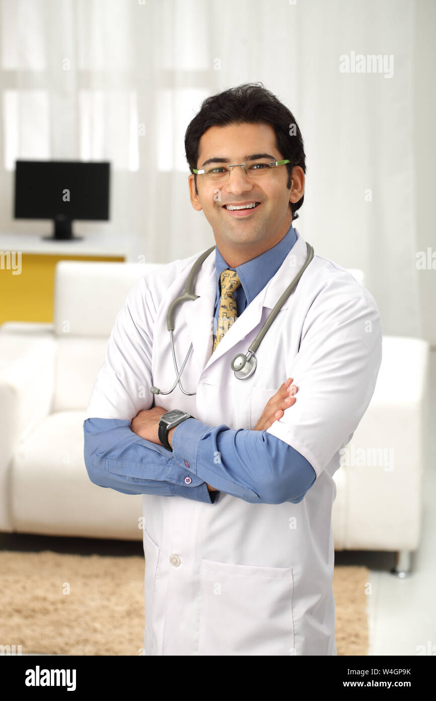 Male doctor standing with his arms crossed Stock Photo - Alamy