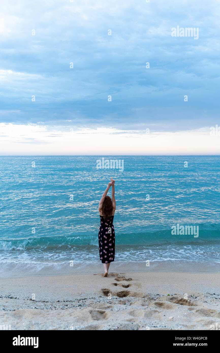 Back view of young woman at seafront Stock Photo - Alamy