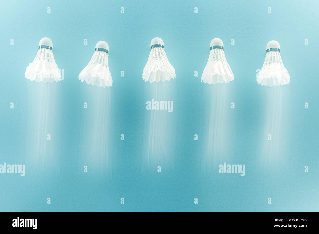 motion blur of white shuttlecocks with feathers flying on blue Stock ...