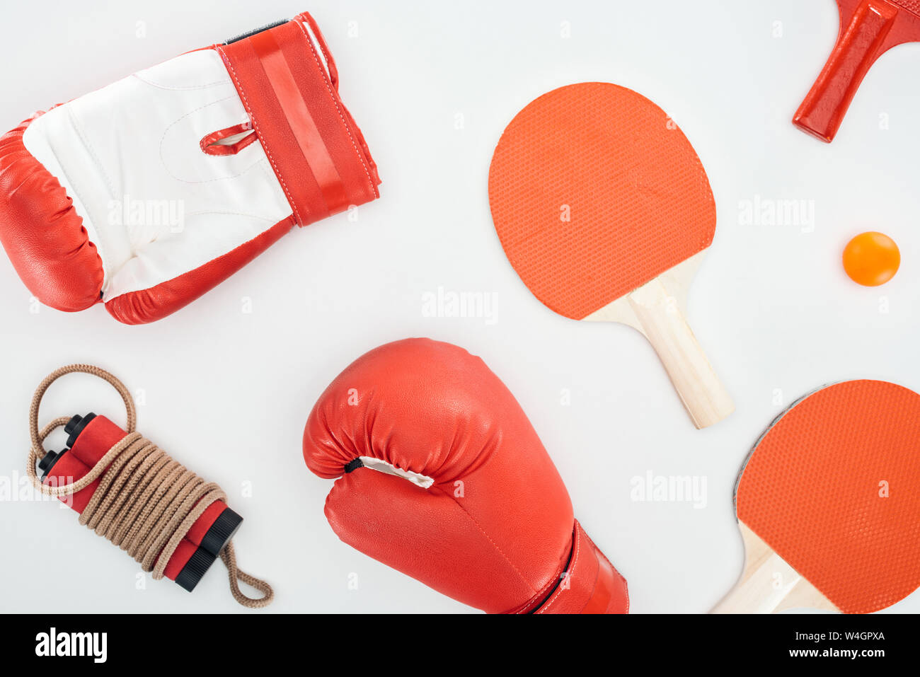 top view of boxing gloves near red ping pong rackets and skipping rope ...